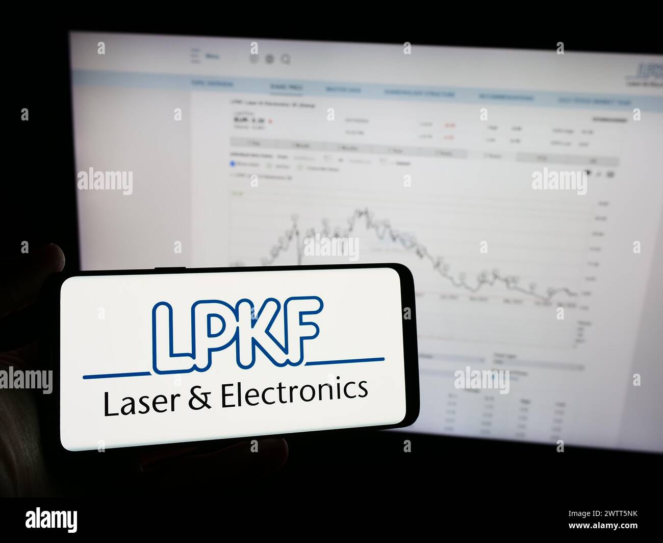 Person holding mobile phone with logo of German technology company LPKF ...