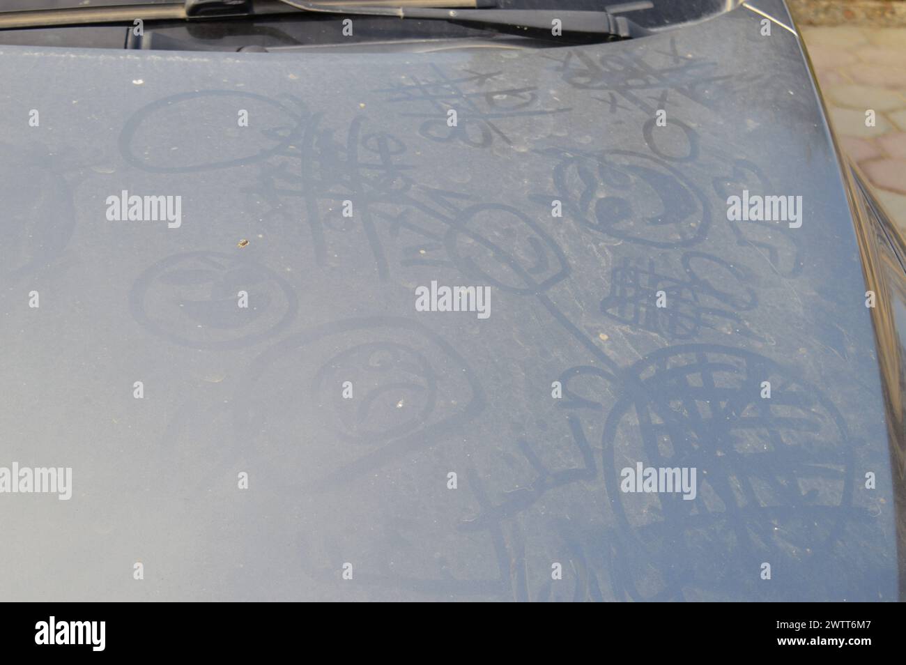 illustrations and kids' games on a dusty car engine hood, a dusty car ...