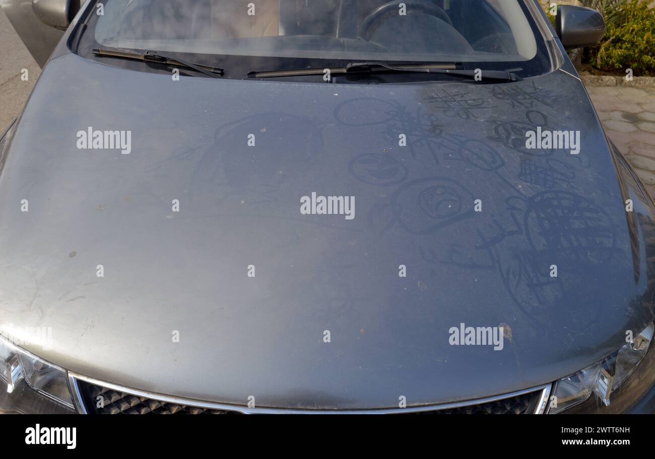 illustrations and kids' games on a dusty car engine hood, a dusty car ...