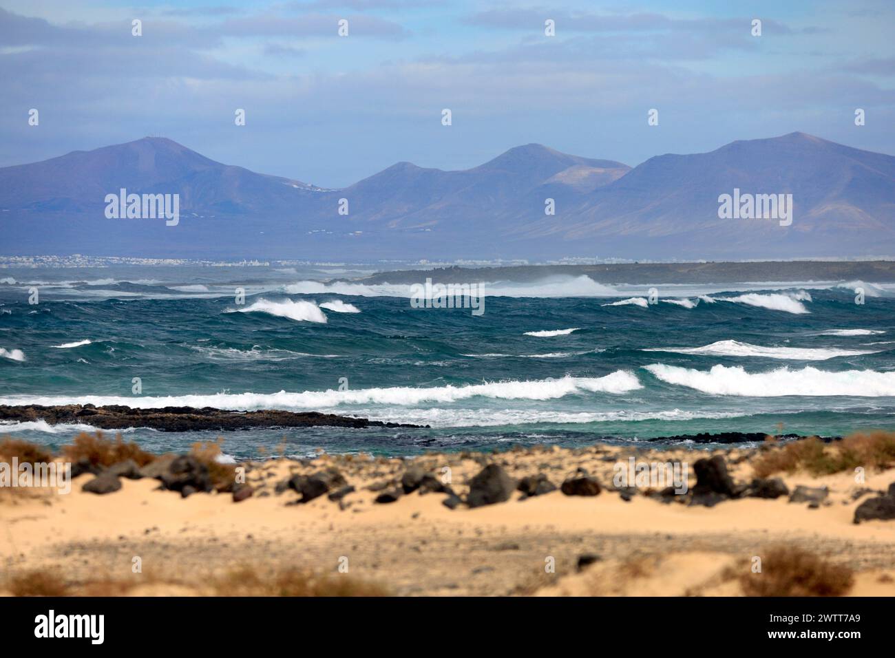 View of rough sea with Lanzarote in distance from Punta Tostón ...