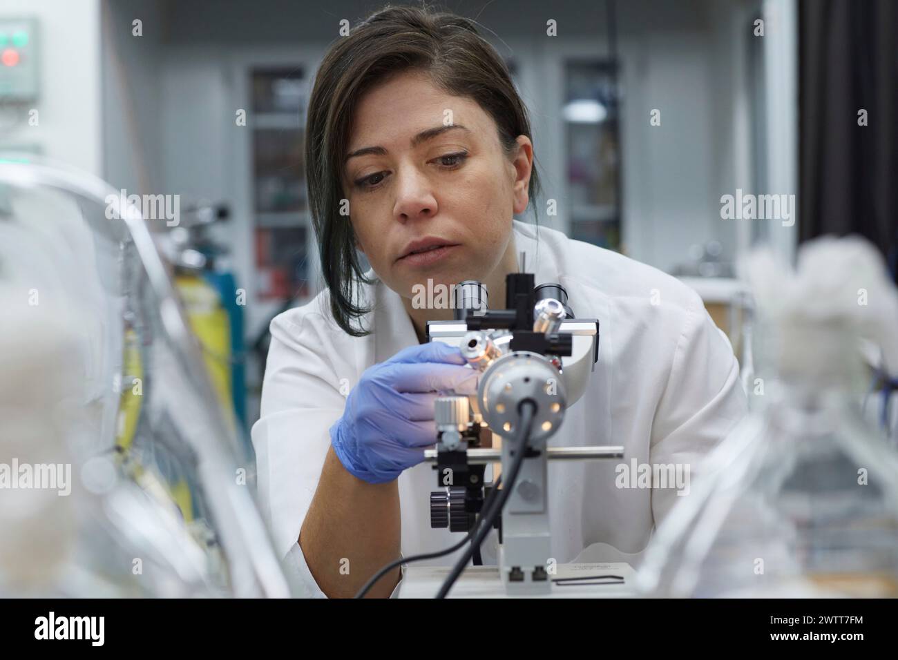 Attractive female scientist testing using microscope to test for dna ...