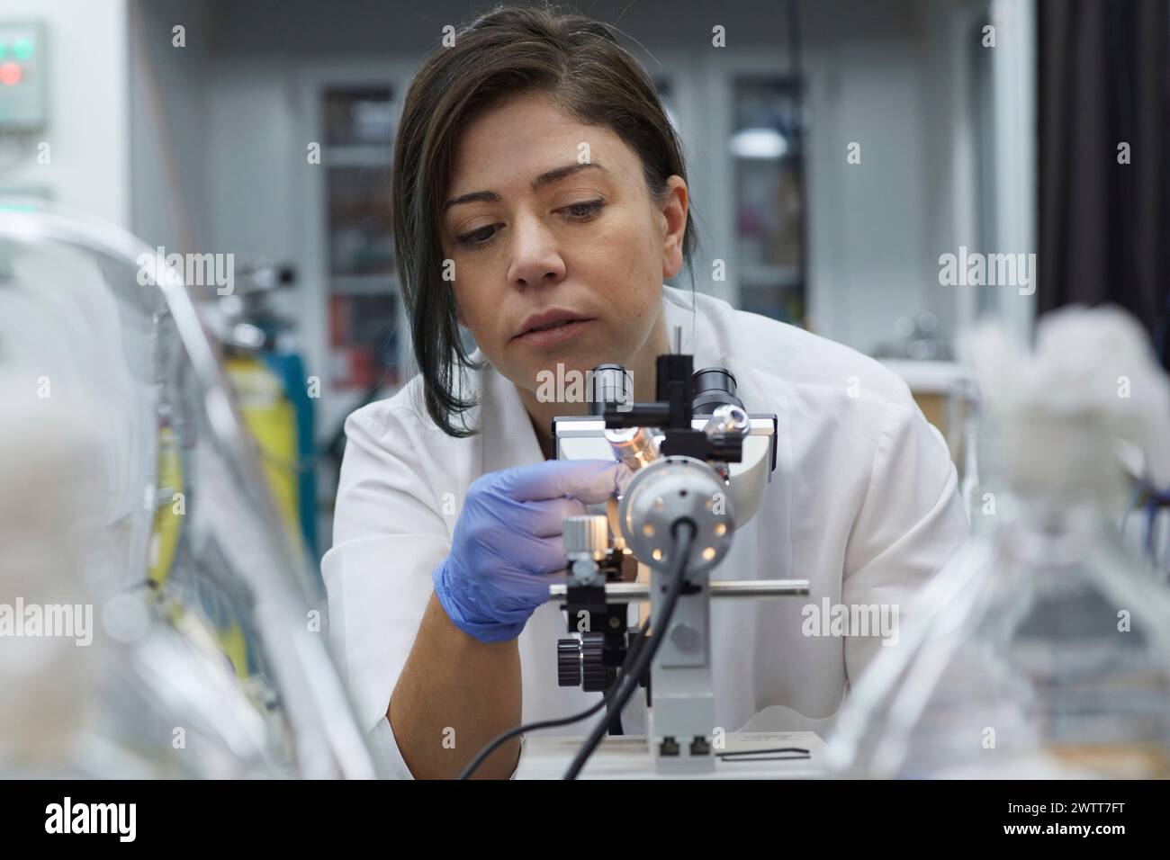 Attractive female scientist testing using microscope to test for dna ...