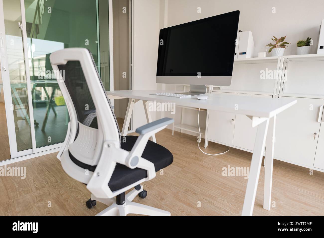White table and chair with computer monitor and modern file cabinet in ...