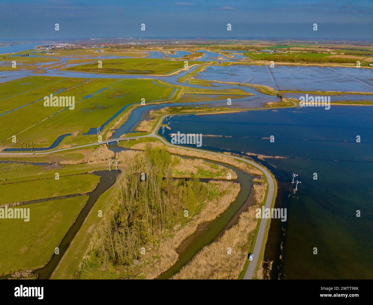 Aerial view of a serpentine waterway winding through lush green fields ...