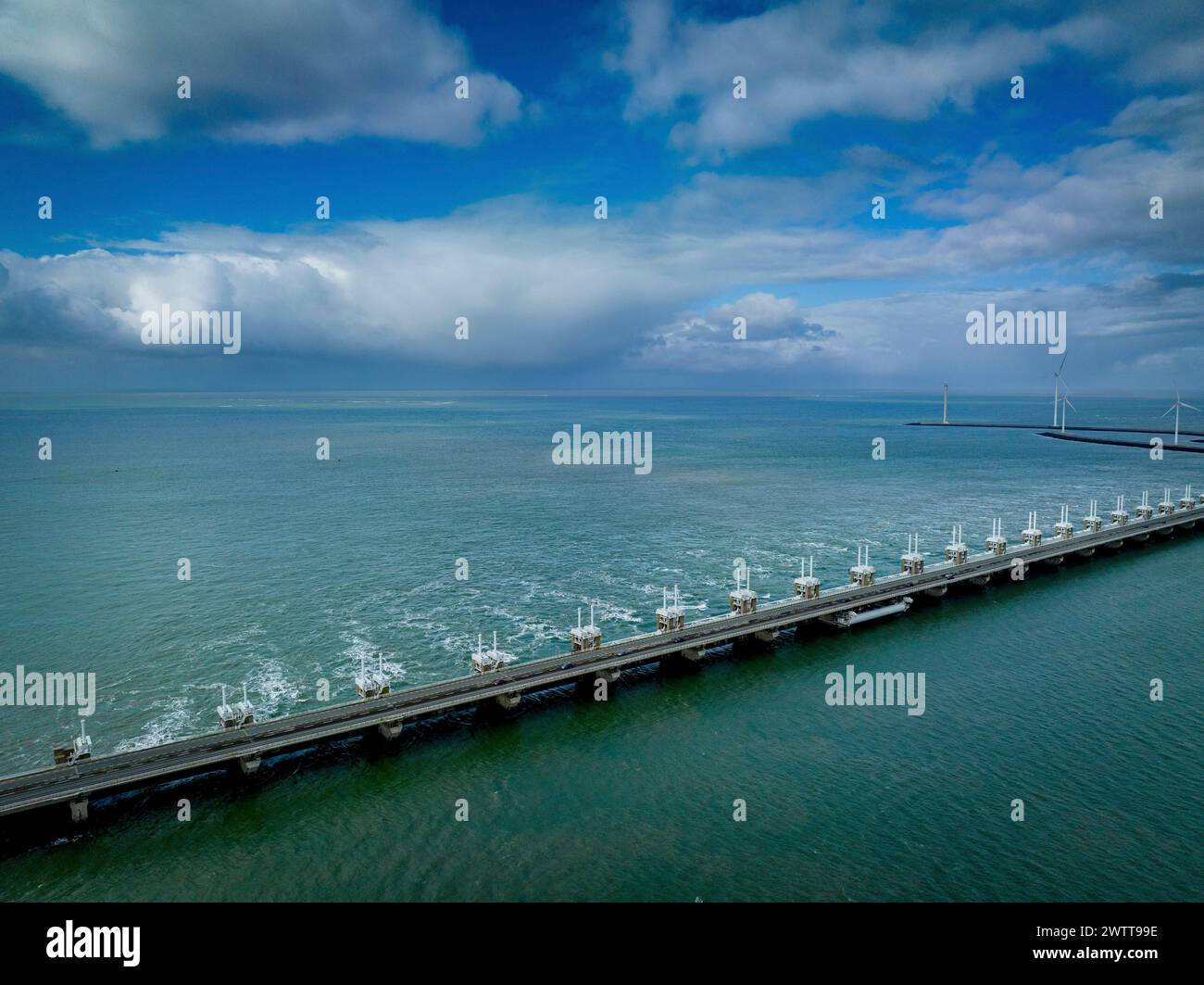 A tranquil aerial view of a pier stretching into a serene blue sea ...