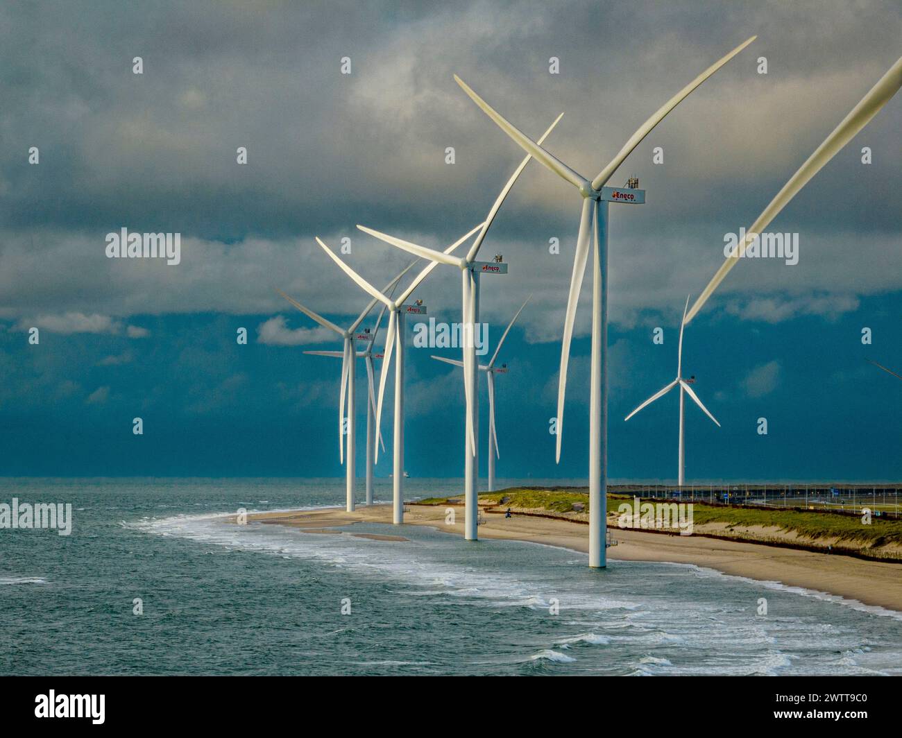 Wind turbines standing tall by the seaside under a dramatic sky Stock ...