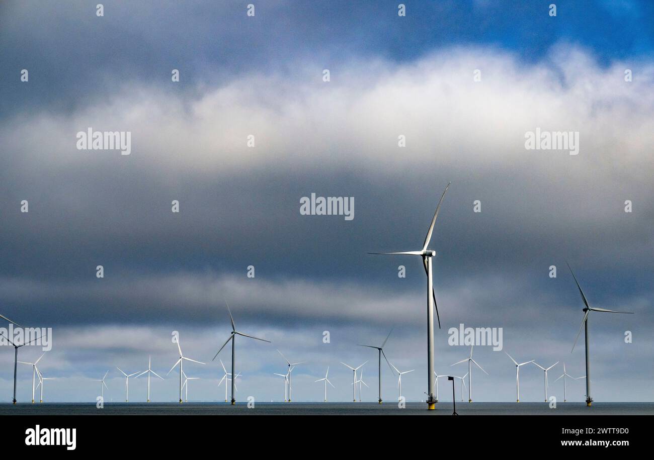 Wind turbines standing tall against a dramatic cloudy sky Stock Photo ...