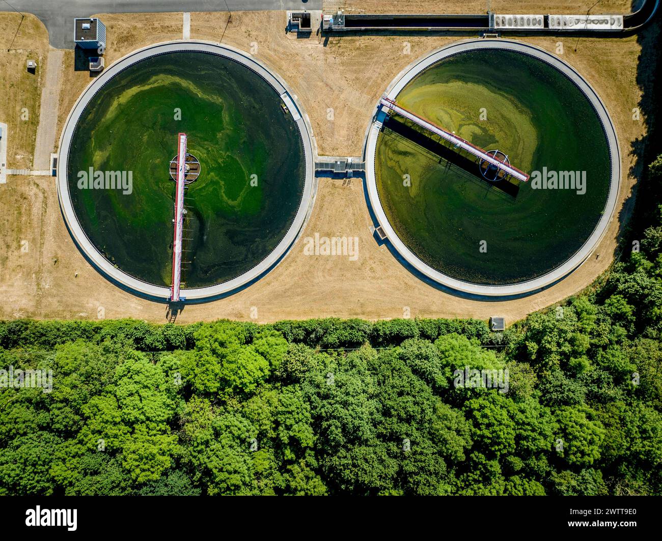 Overhead view of circular water treatment basins surrounded by greenery ...