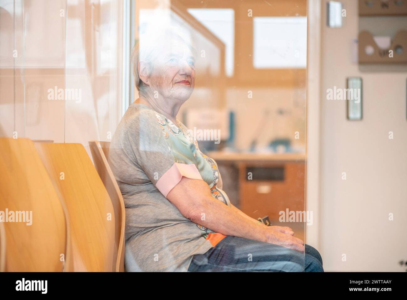 Elderly woman smiling behind a window Stock Photo - Alamy