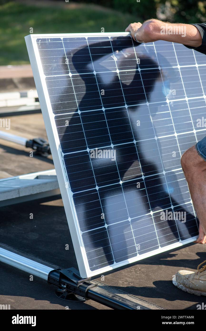Man installing a solar panel with a focused shadow cast upon it Stock ...