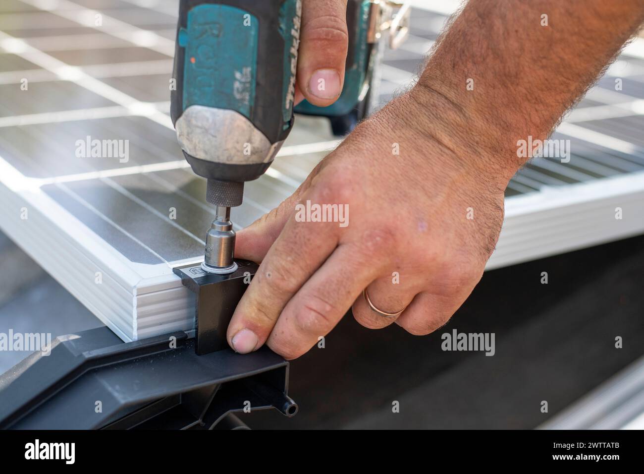 Craftsperson fastening solar panel components with an electric ...