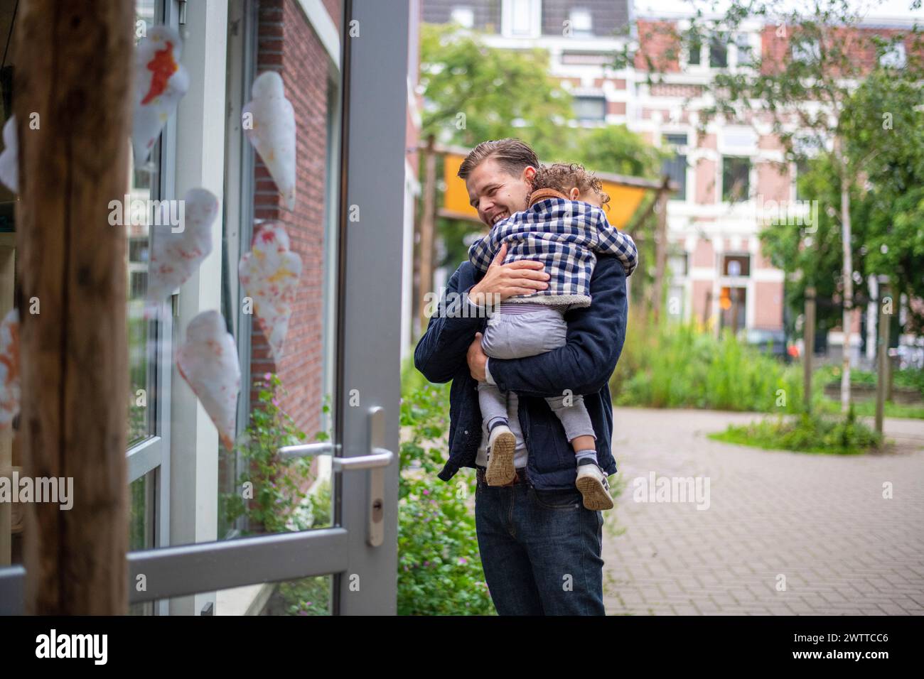 Father and child enjoying a heartwarming hug on a city sidewalk Stock ...