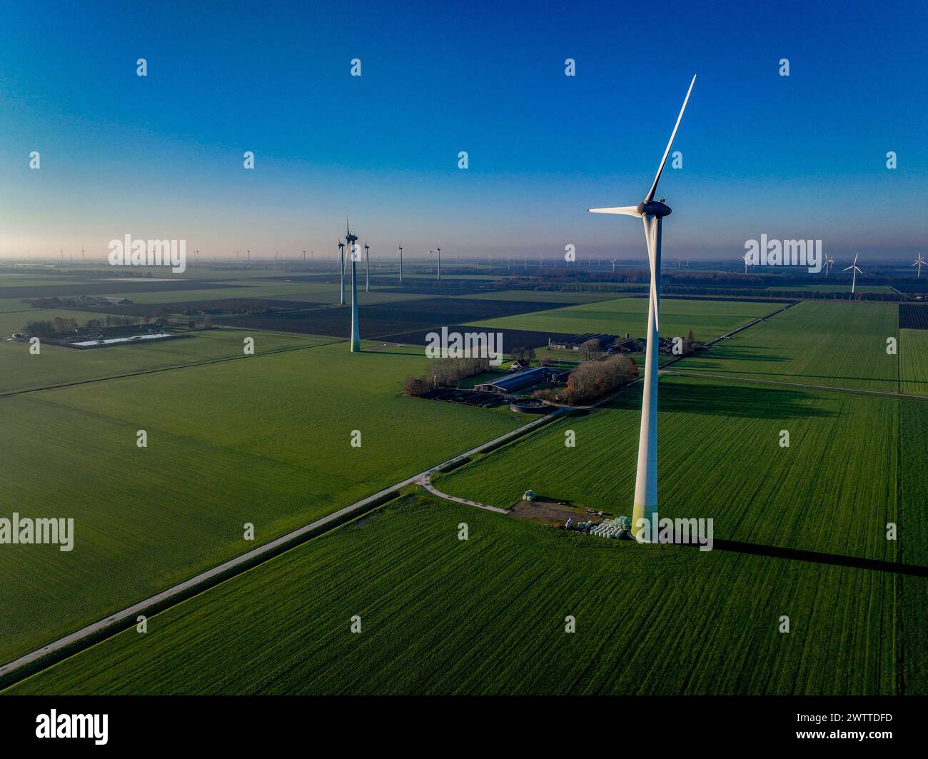 A serene dawn over a wind farm with sprawling green fields Stock Photo ...