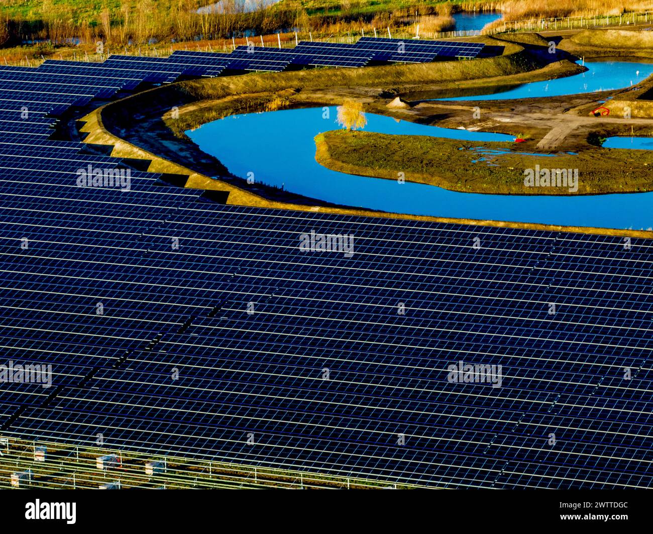 Solar panels lining a curving body of water at sunset Stock Photo - Alamy