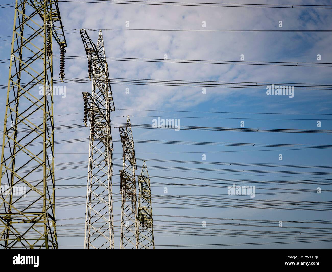 Electricity pylons stretching across a cloudy sky Stock Photo - Alamy