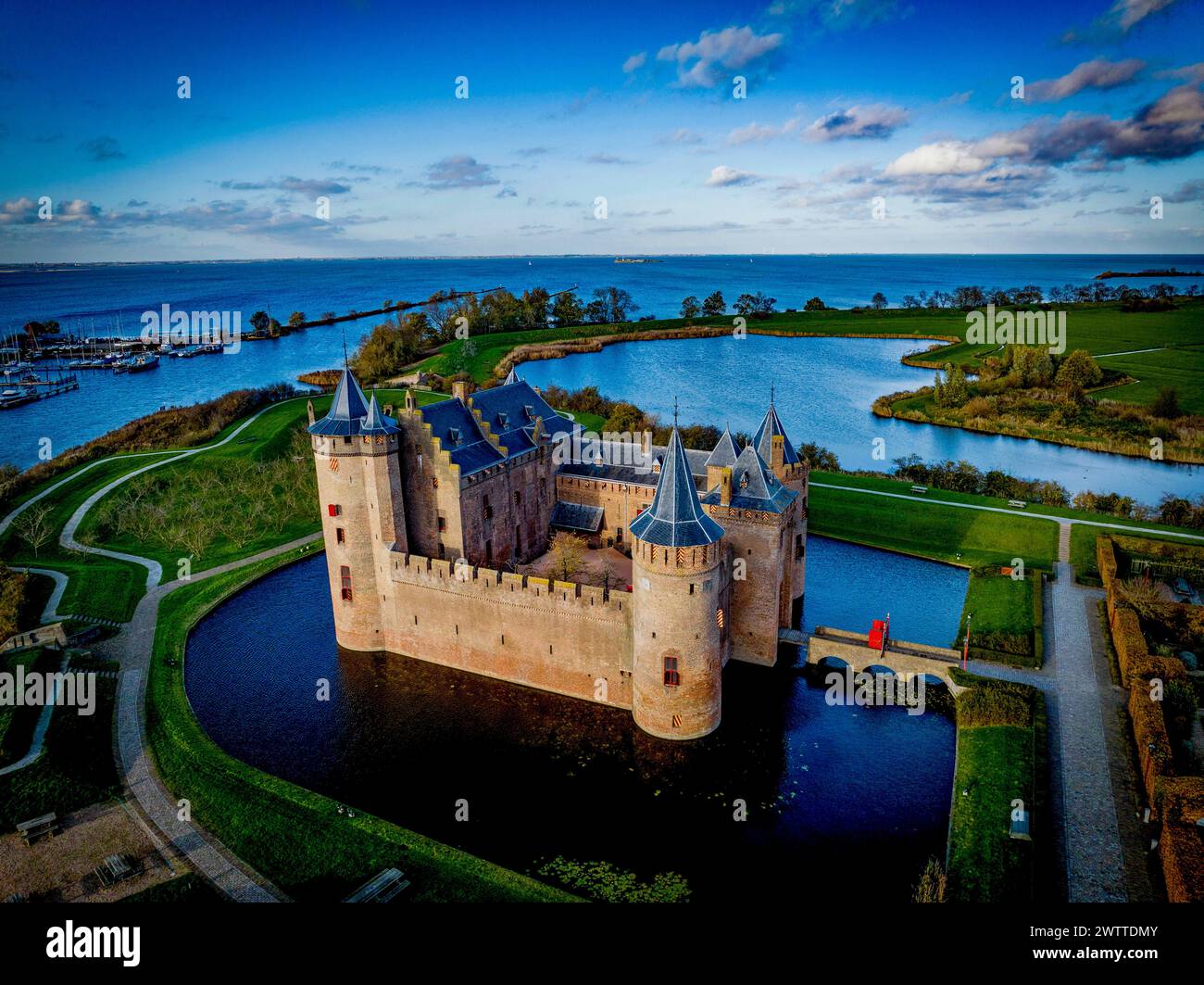 Aerial view of a majestic castle surrounded by a serene moat at dusk ...