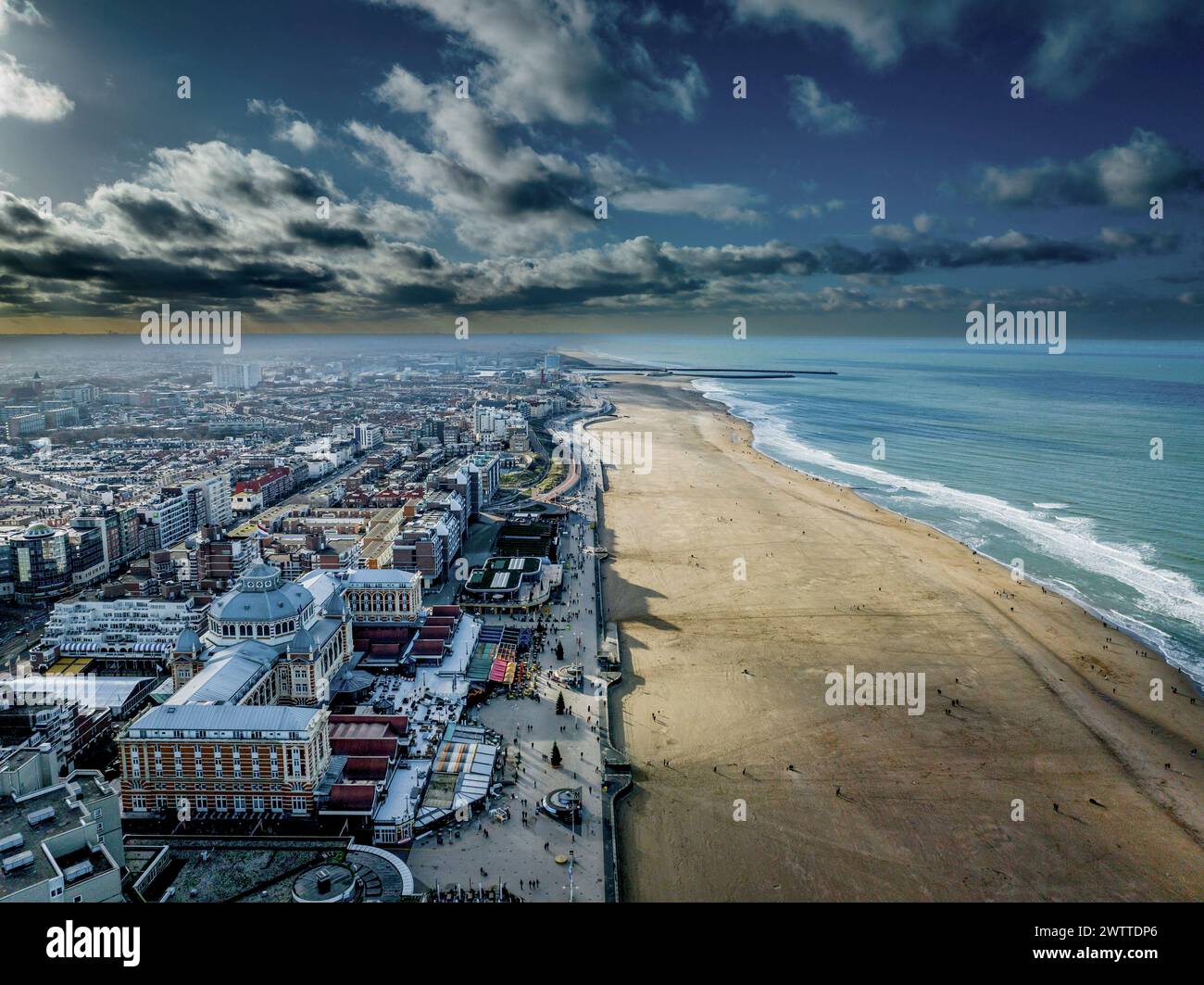 Aerial view of a bustling beachfront cityscape under a dramatic sky ...
