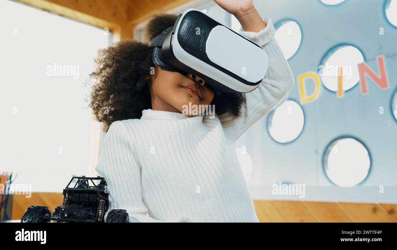 Creative girl wearing VR headset to learning in metaverse. Funny kid ...