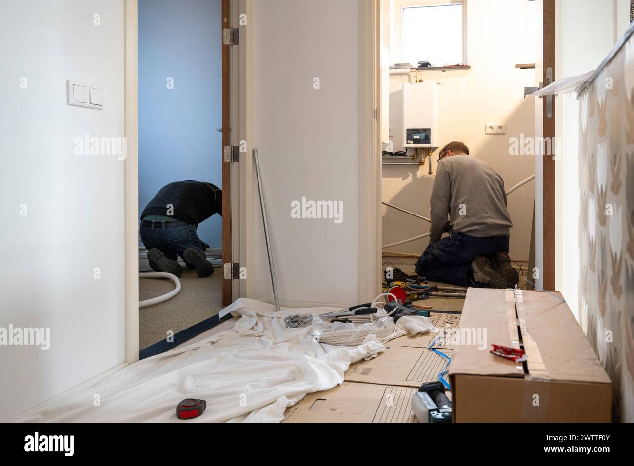 Two people busy with home renovation tasks Stock Photo - Alamy