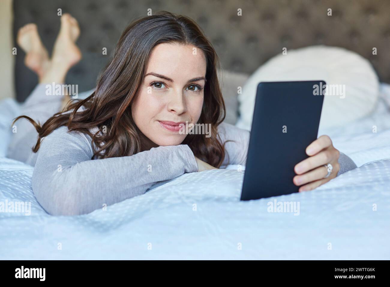 Woman lying on bed tablet hi-res stock photography and images - Alamy