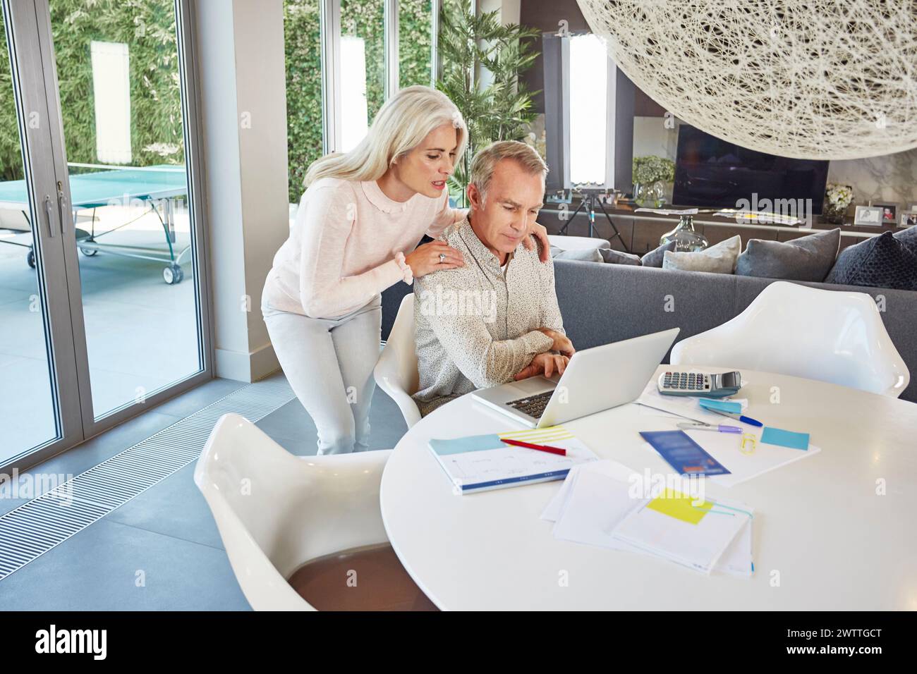 Two people working on a laptop in a modern home Stock Photo - Alamy