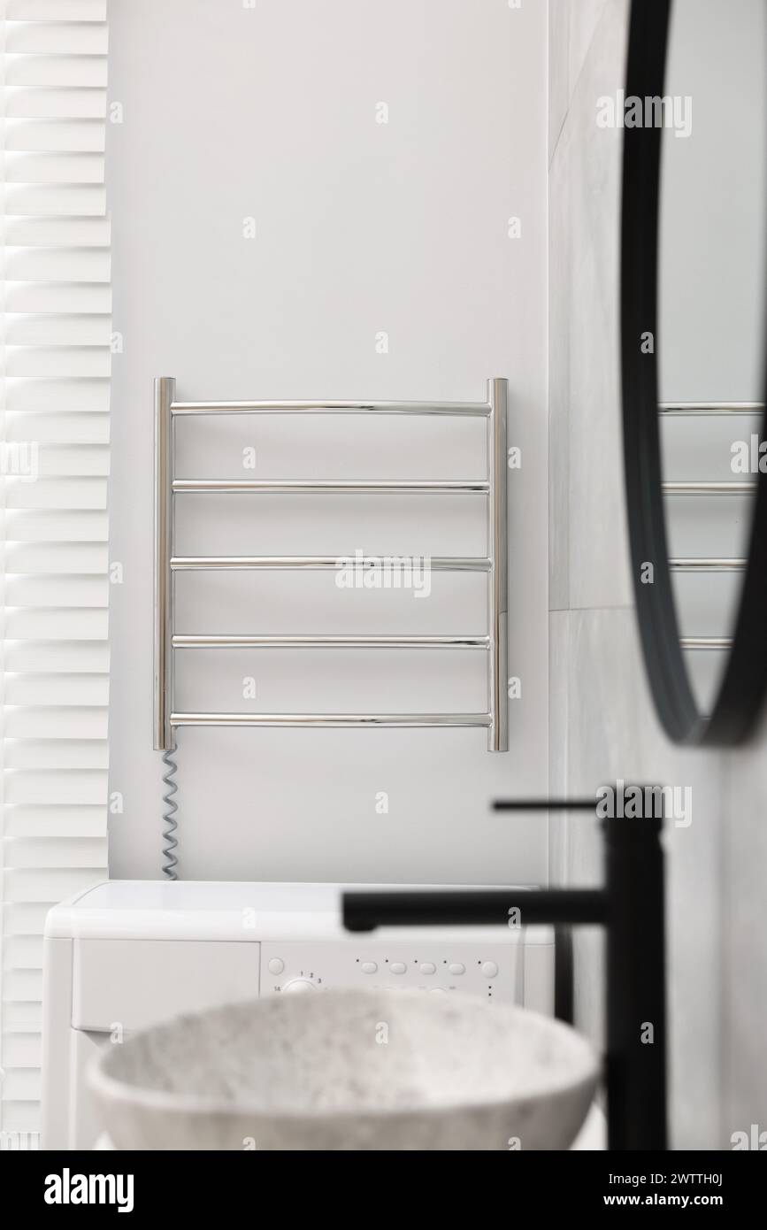 Modern heated towel rail on wall in bathroom Stock Photo - Alamy