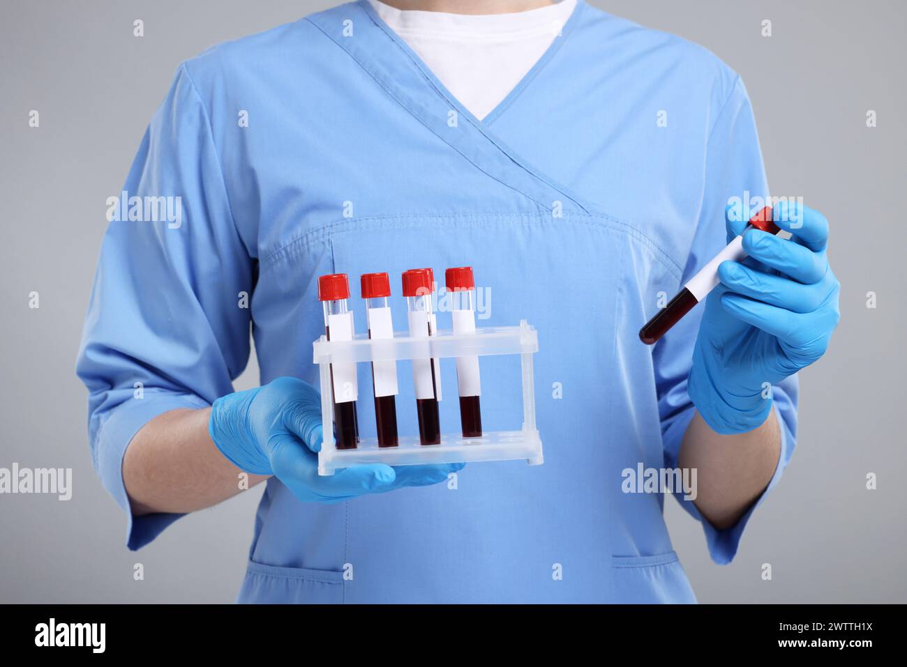 Laboratory testing. Doctor with blood samples in tubes on light grey ...