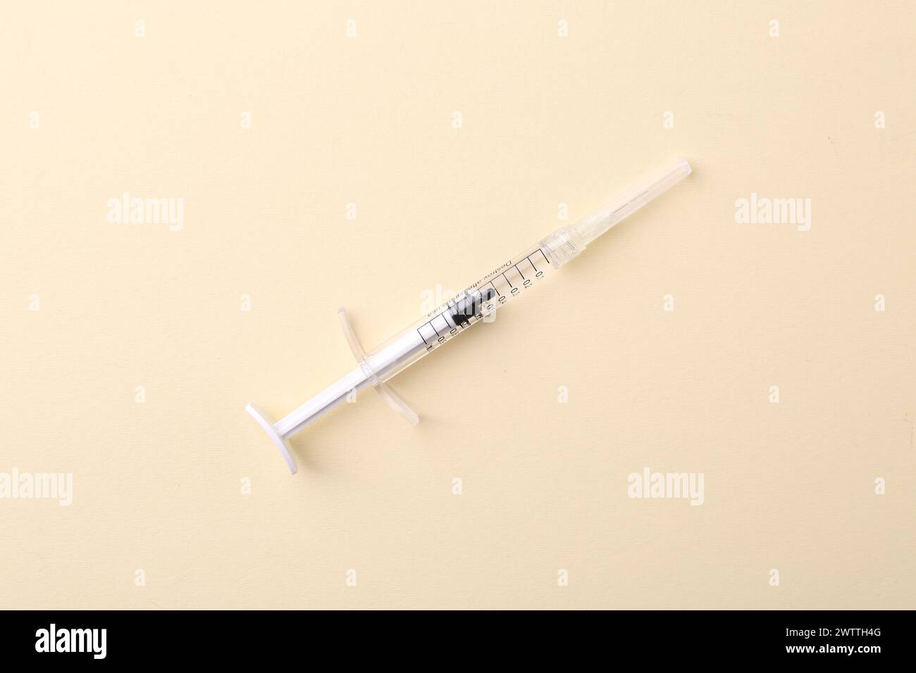 Injection cosmetology. One medical syringe on beige background, top ...