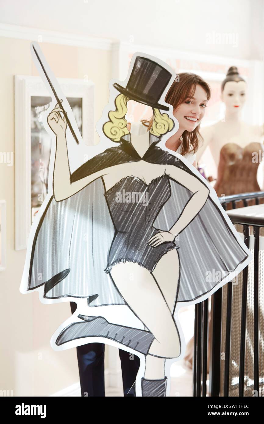 Woman posing behind a cutout of a dancing figure Stock Photo - Alamy
