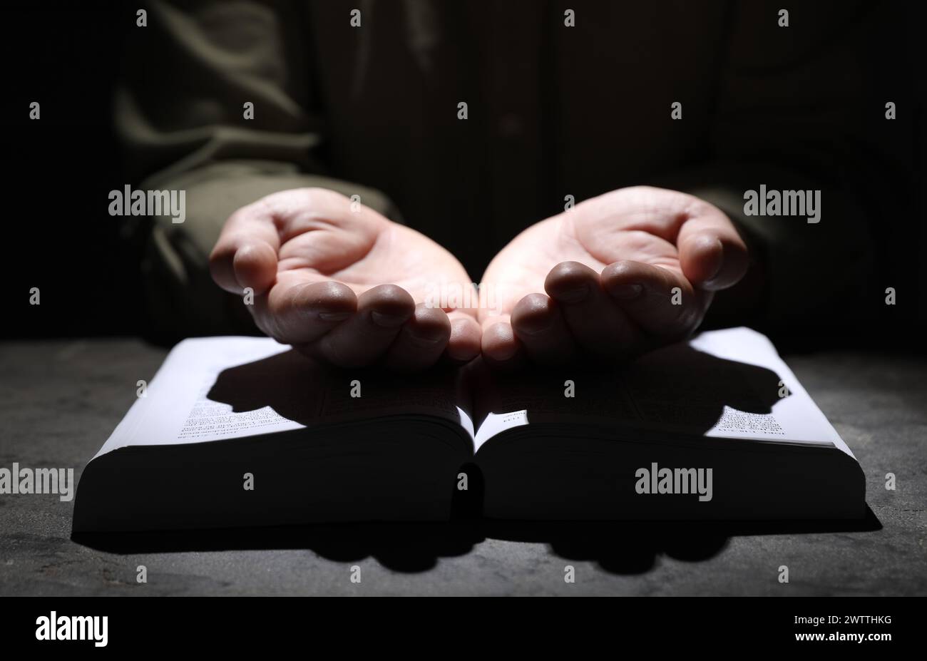 Religion. Christian man praying over Bible at table, closeup Stock ...