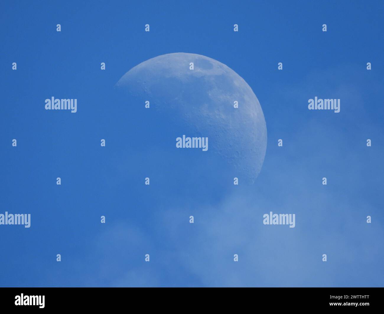 Half moon shining in sky with clouds and blue background Stock Photo ...