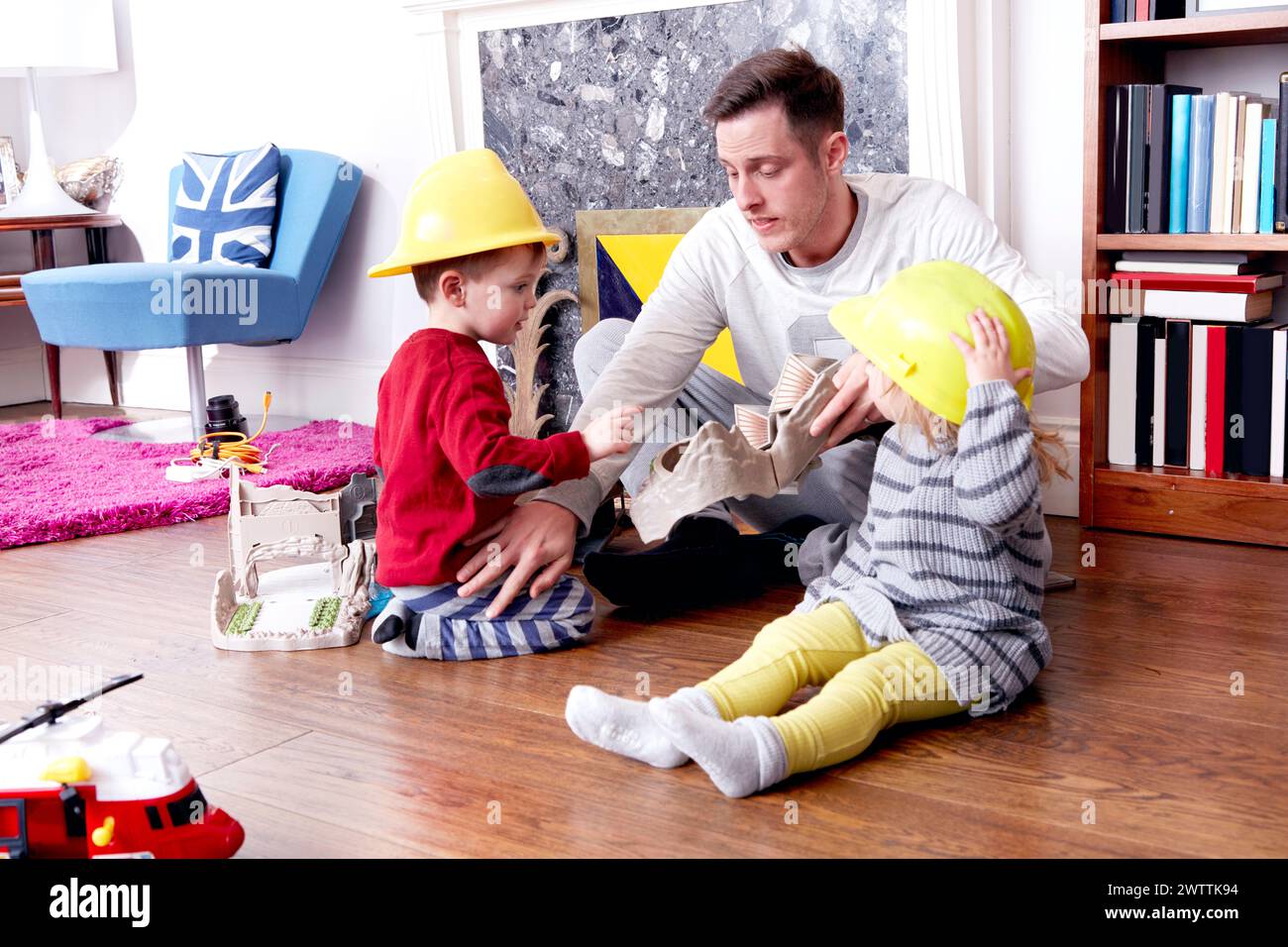 Father and children playing with toys on the floor Stock Photo - Alamy
