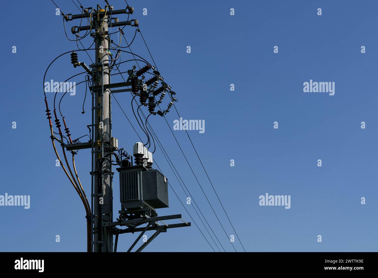 A telephone pole covered in a tangle of wires, illustrating the ...