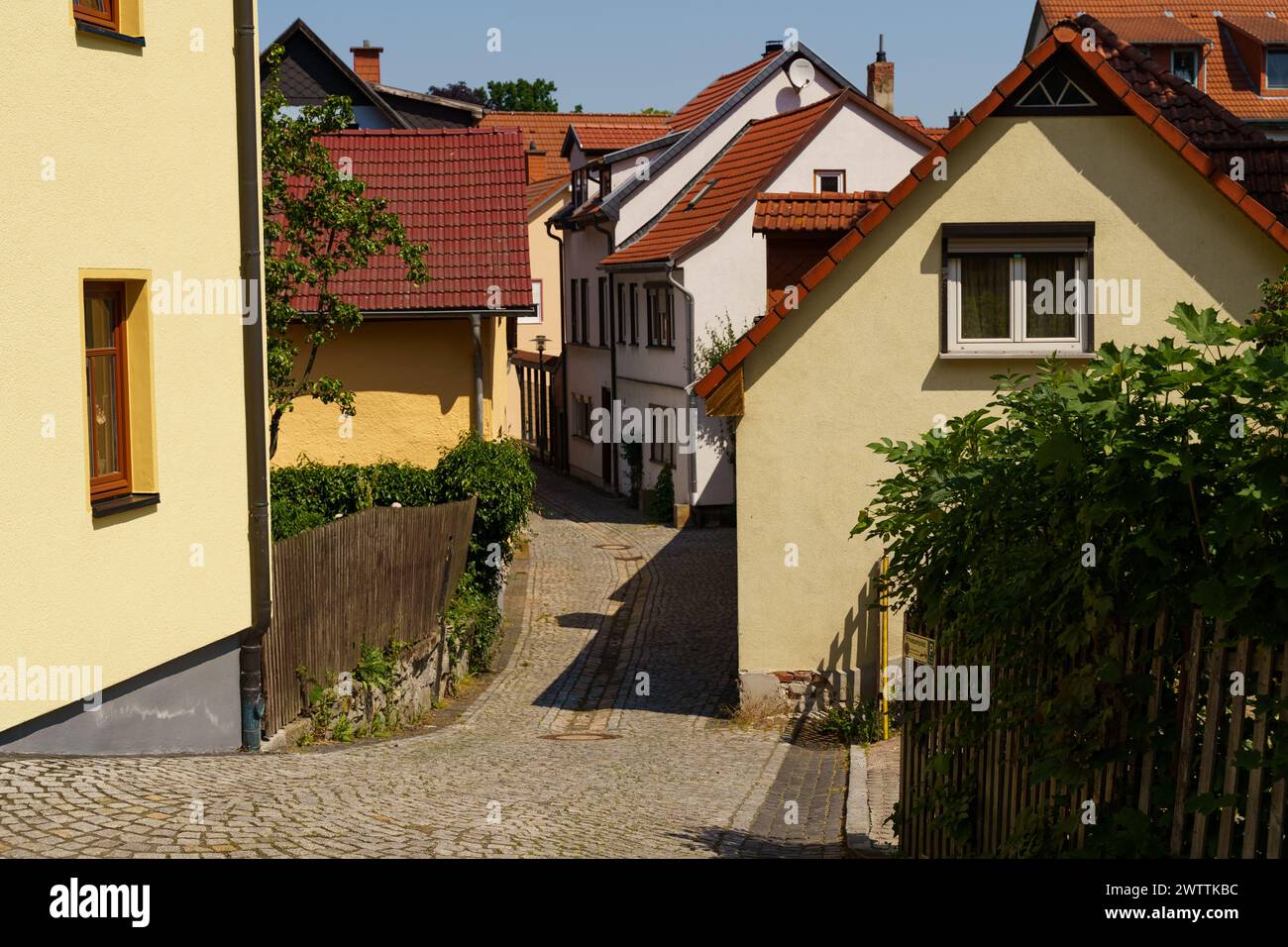 German city. A narrow cobblestone street lined with traditional houses ...