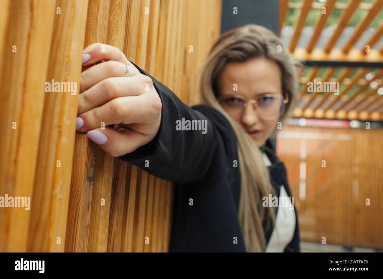 A female person grasping onto a wooden wall with her hands Stock Photo ...