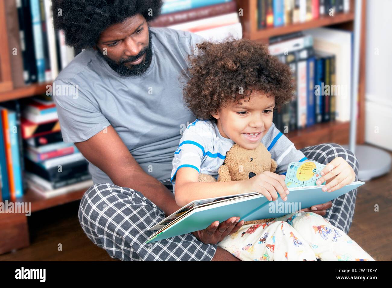 Father and child reading a book together Stock Photo - Alamy