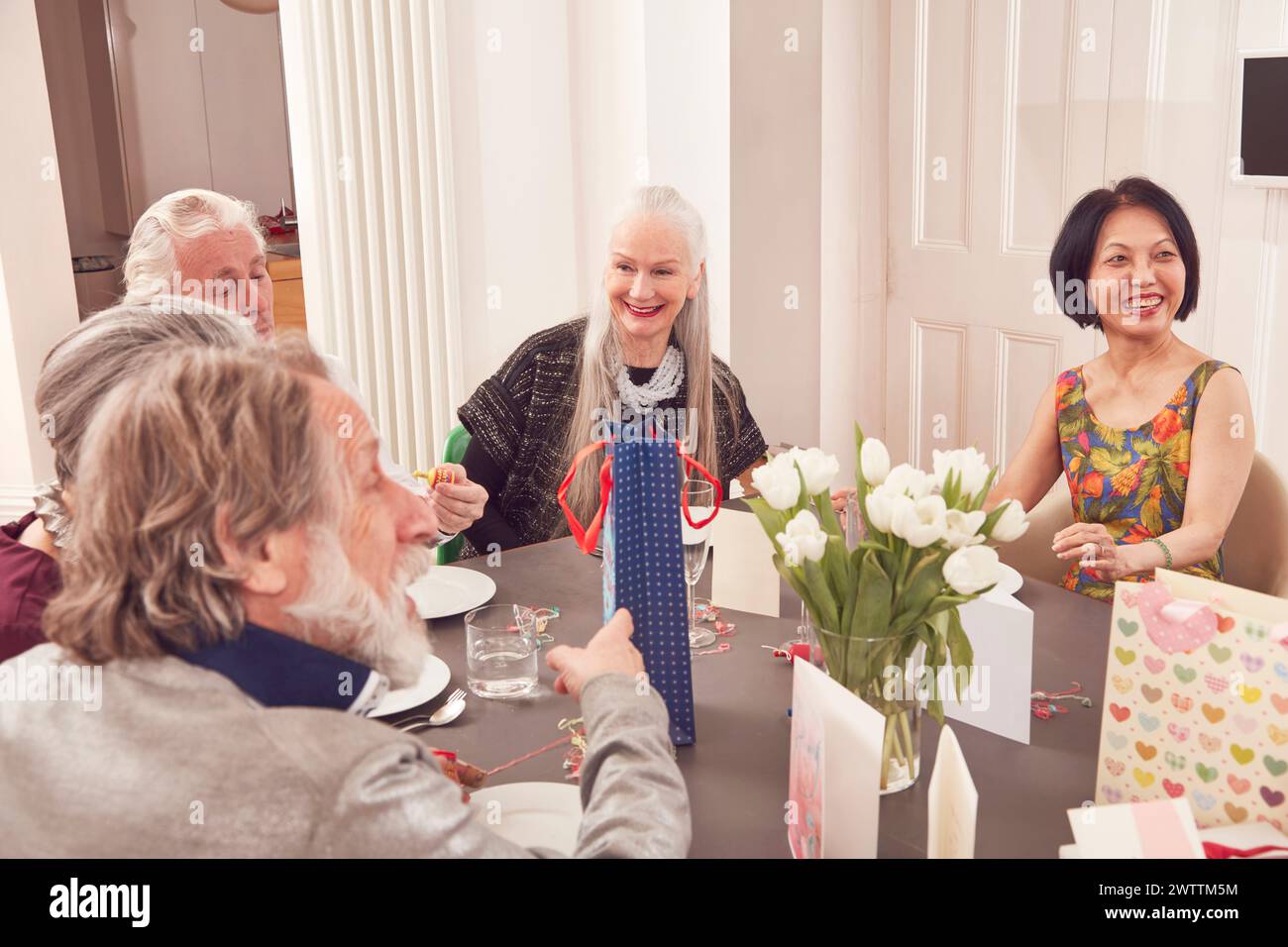Group of adults enjoying a celebration at a dining table Stock Photo ...