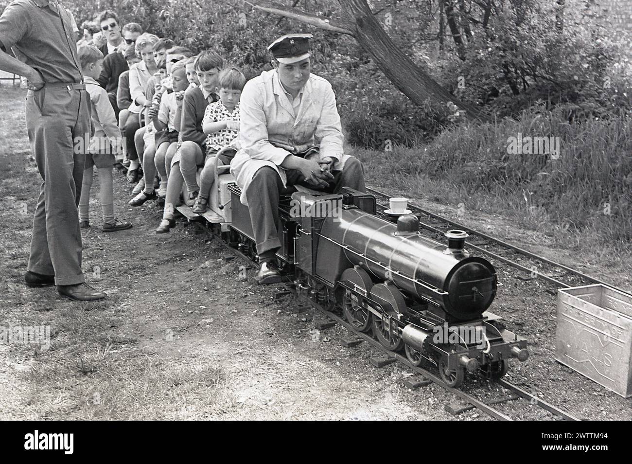 1960s, historical, summertime and outside families enjoying a ride on a ...
