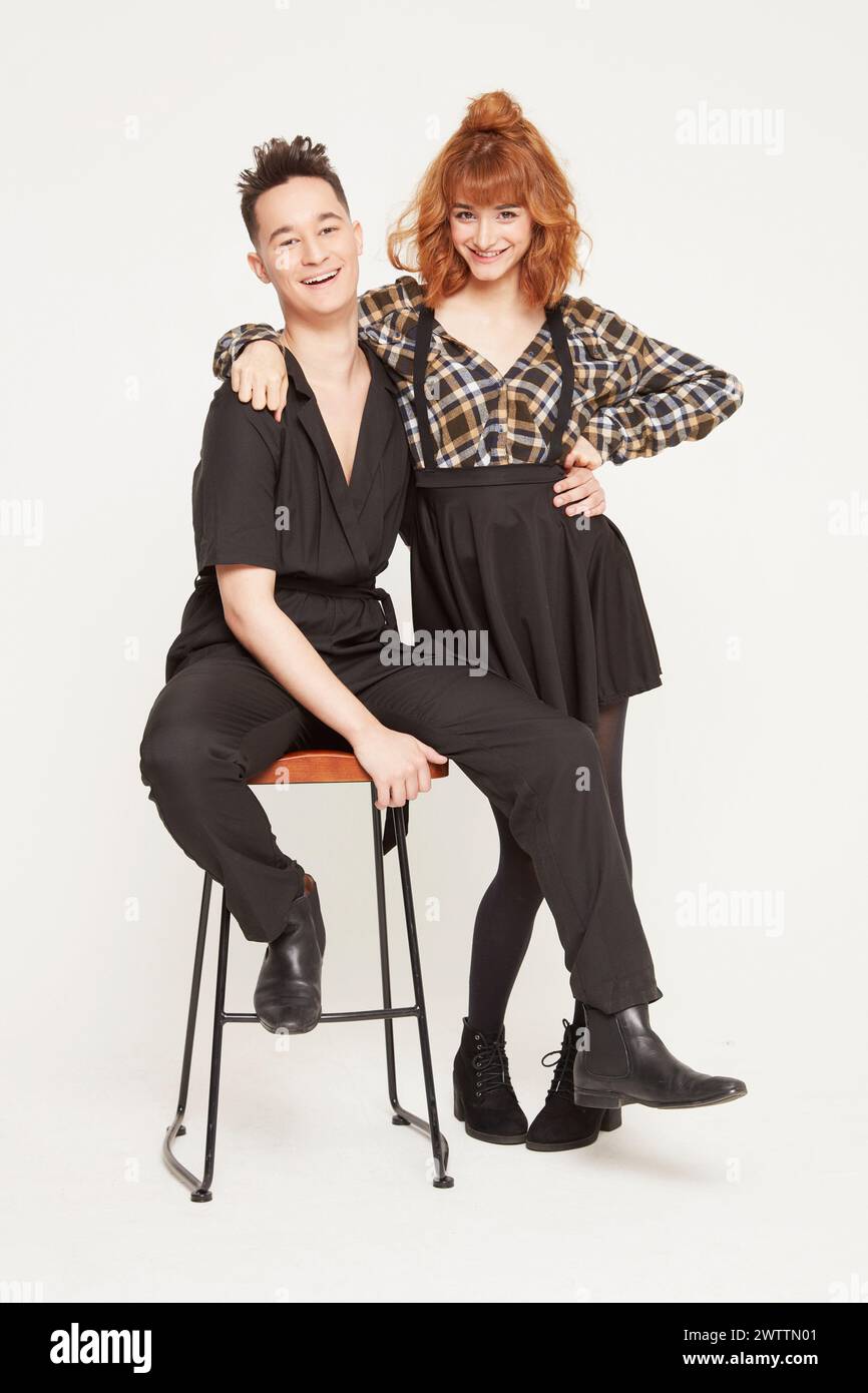 Two people posing in stylish outfits on a white background Stock Photo ...
