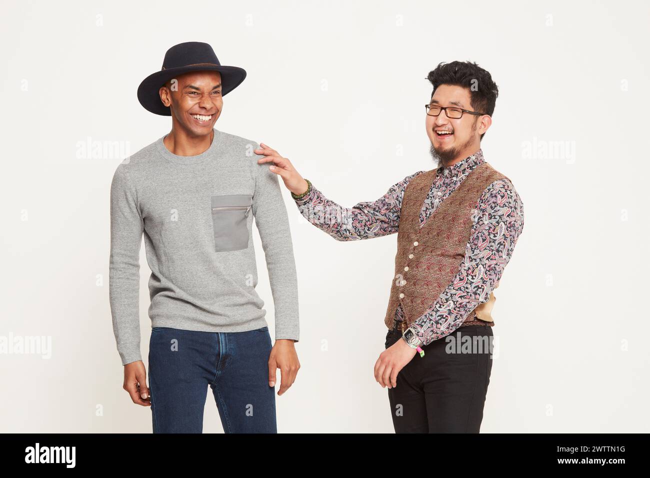 Two men laughing and interacting on a white background Stock Photo - Alamy