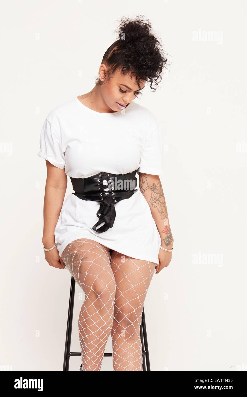 Stylish person sitting on a stool Stock Photo - Alamy