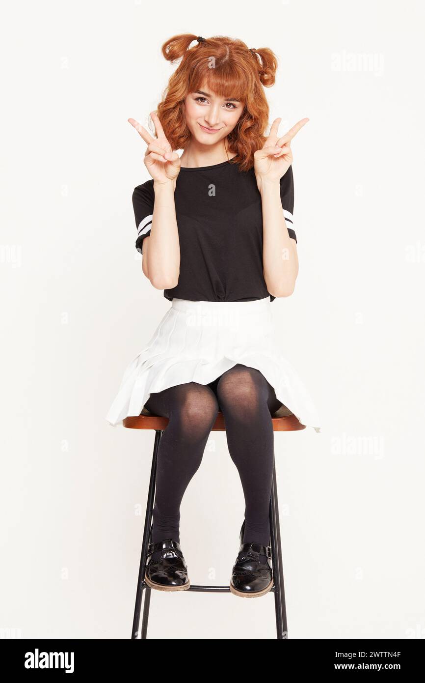 Woman posing with peace signs in a cute outfit Stock Photo - Alamy