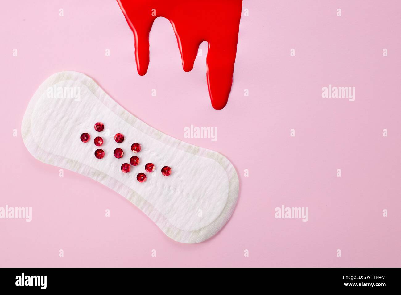 Blood and feminine hygiene pad with red glitter on pink background ...