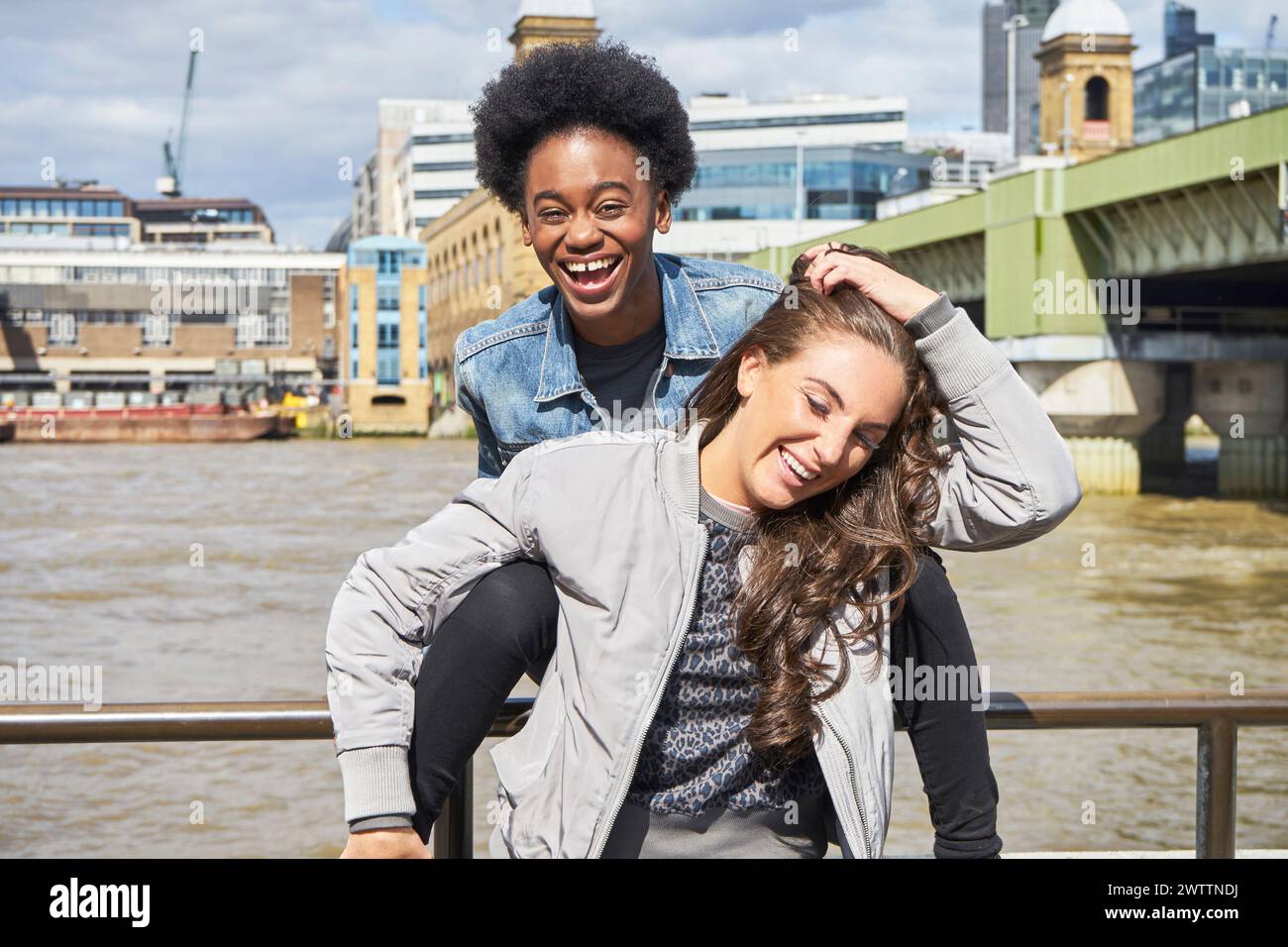 Two friends smiling by the river Stock Photo - Alamy