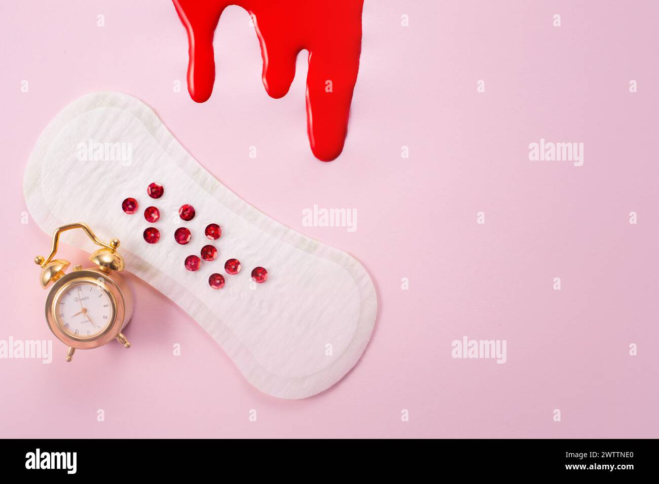 Blood, alarm clock and feminine hygiene pad with red glitter on pink ...