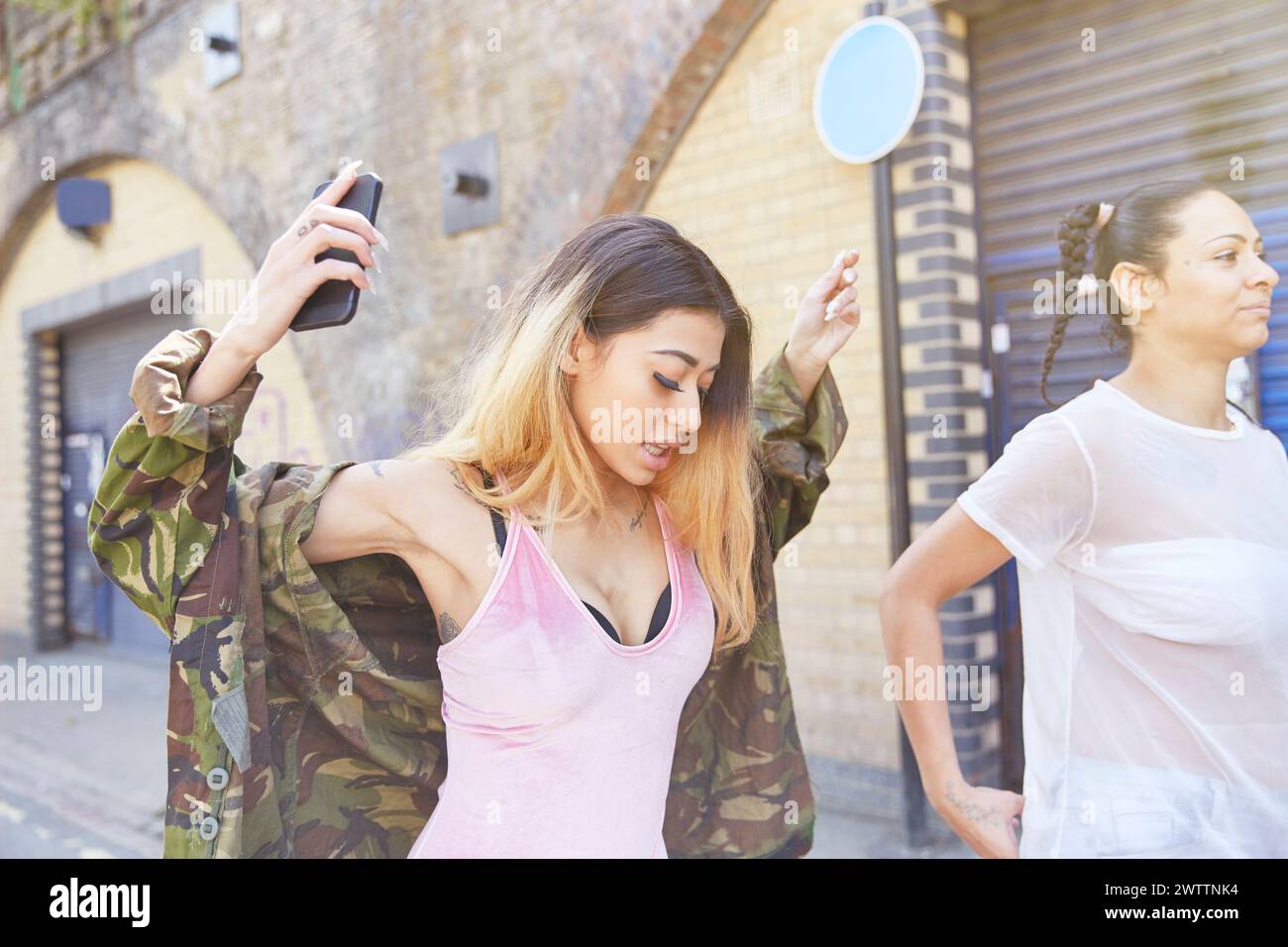 Two women enjoying a dance move outdoors Stock Photo - Alamy