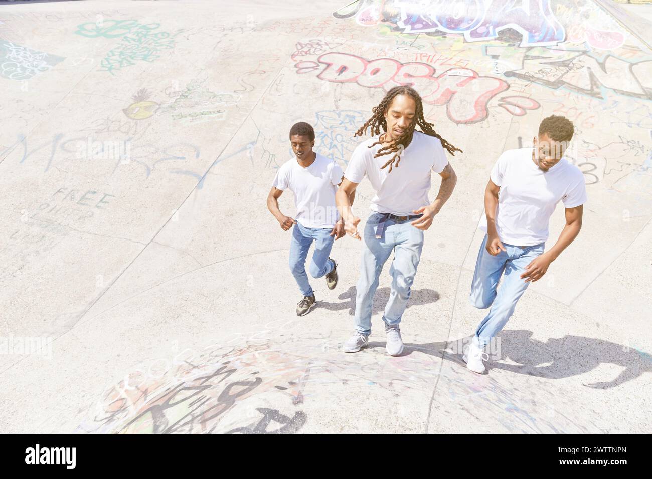 Three people walking on graffiti-covered pavement Stock Photo - Alamy