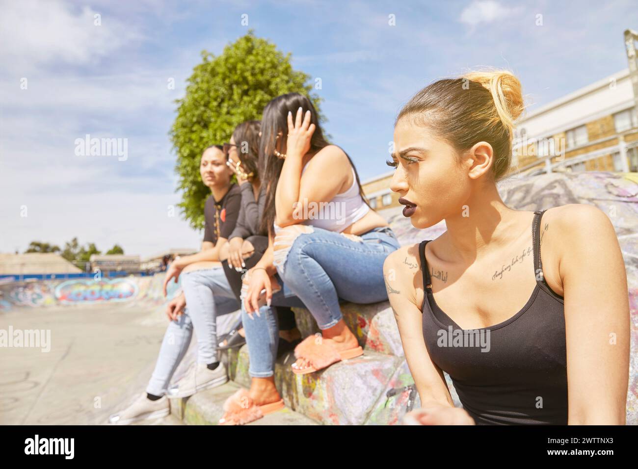 Group of friends sitting on graffiti-covered steps Stock Photo - Alamy