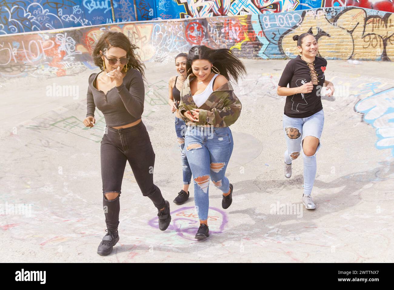 Group of women enjoying themselves at a graffiti-covered location Stock ...