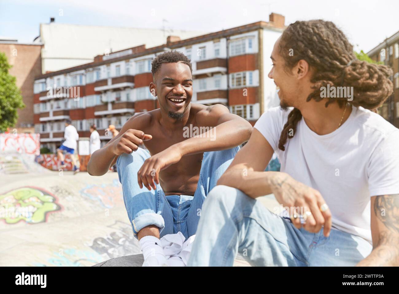 Two friends laughing and chatting outdoors Stock Photo - Alamy